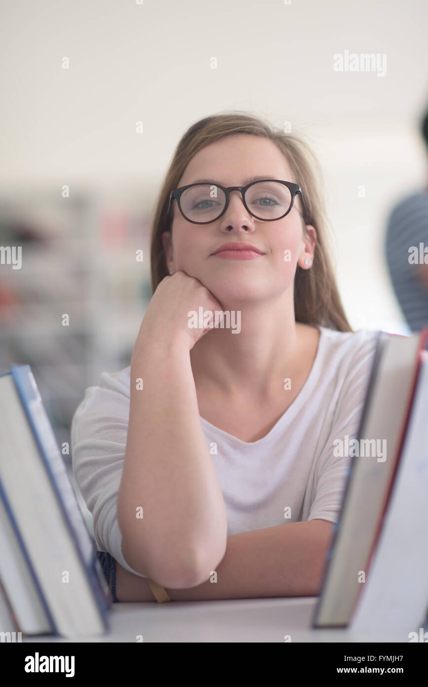 portrait of smart looking famale student girl in collage school library ...