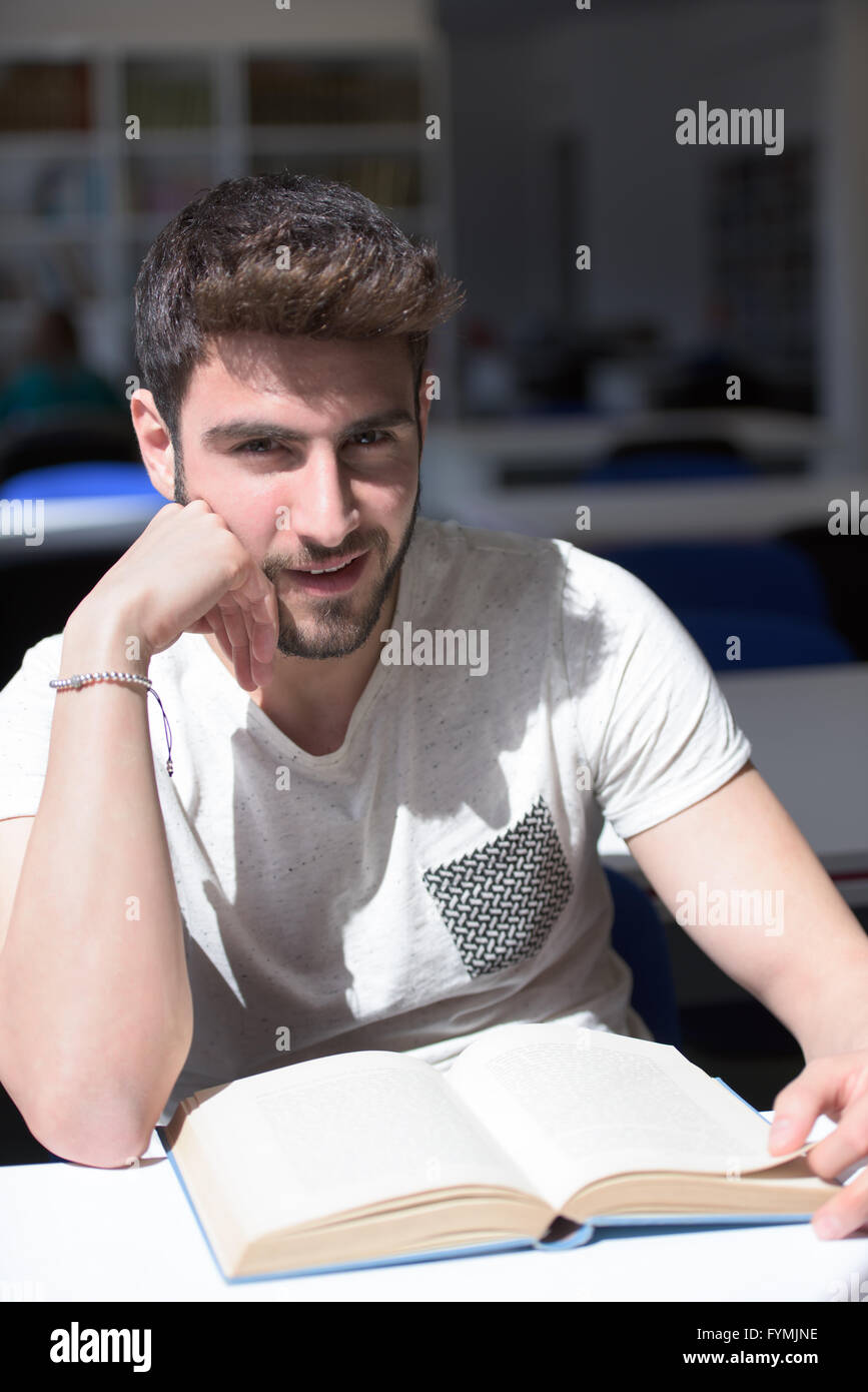 Student reading book in school library. Study lessons for exam. Hard ...