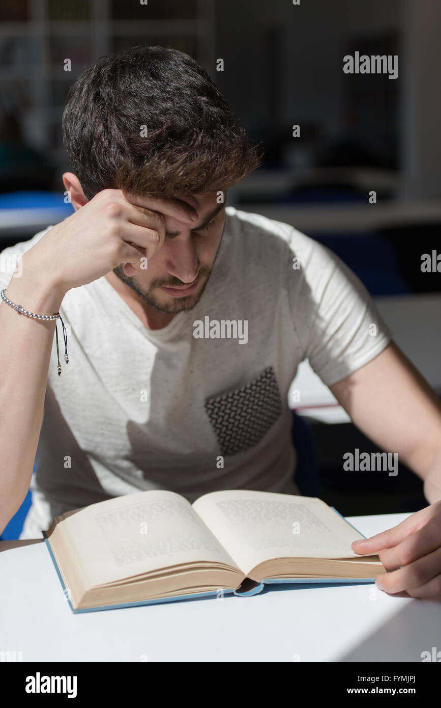 Student reading book in school library. Study lessons for exam. Hard ...