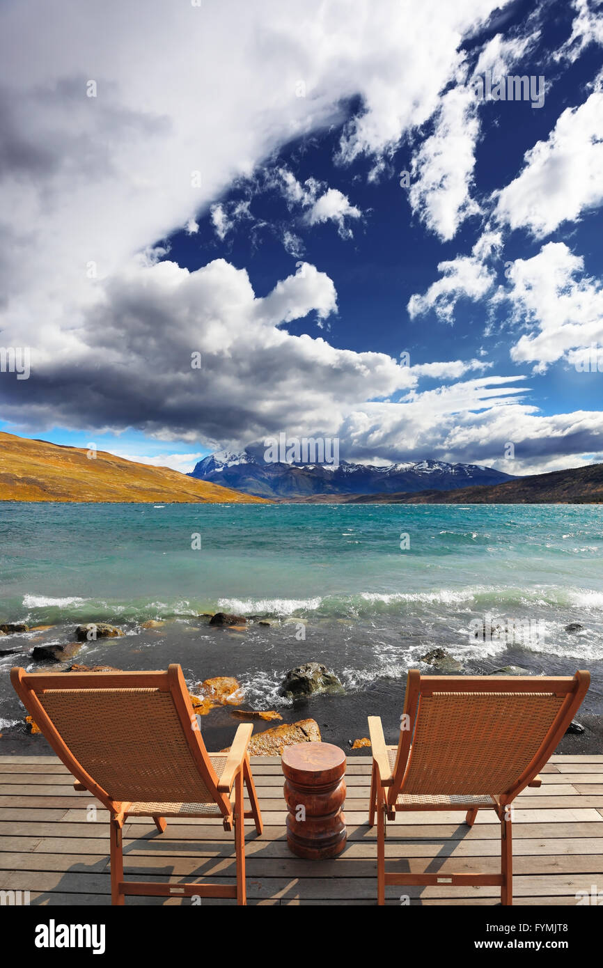 Two folding wooden chairs and a small bedside table Stock Photo - Alamy