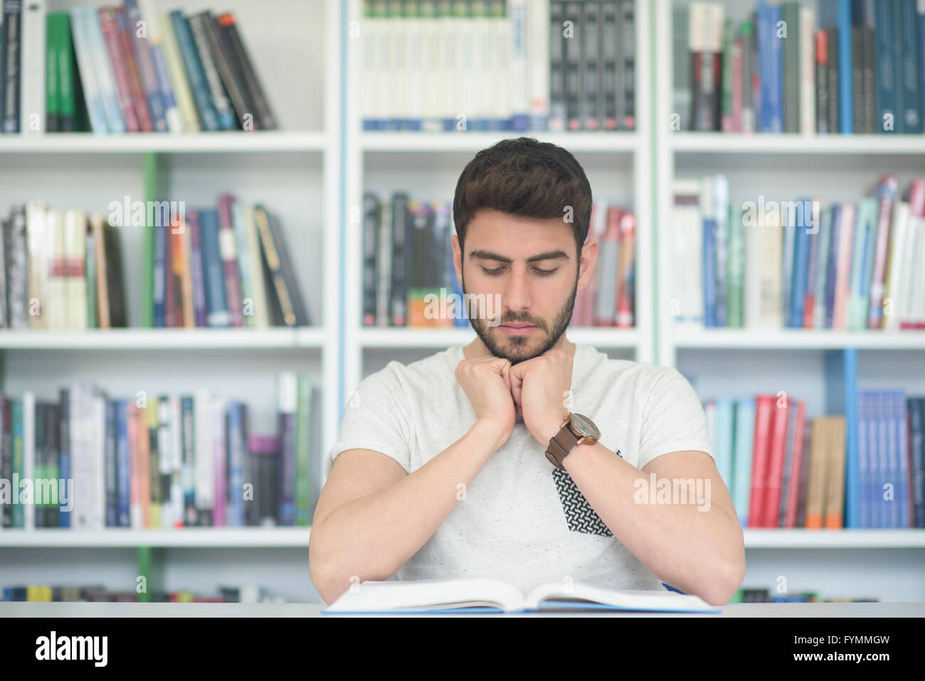 Student reading book in school library. Study lessons for exam. Hard ...
