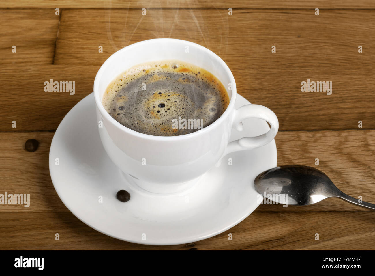 Hot fresh coffee in a white cup with spoon Stock Photo - Alamy