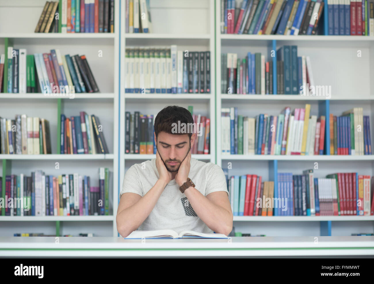 Student reading book in school library. Study lessons for exam. Hard ...