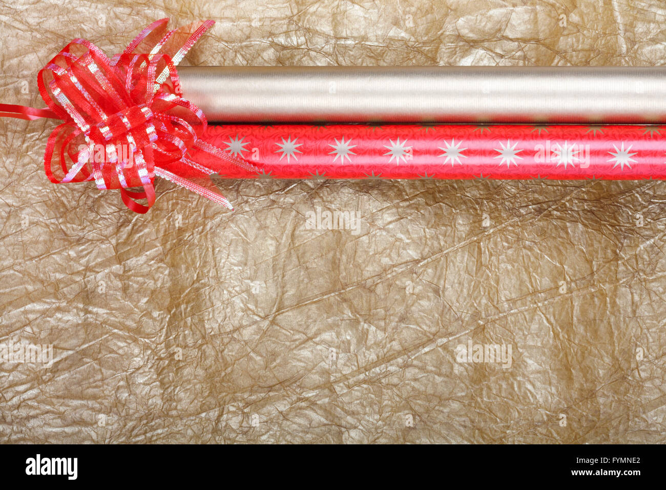 Rolls of multicolored wrapping paper with red bow for gifts on gold ...