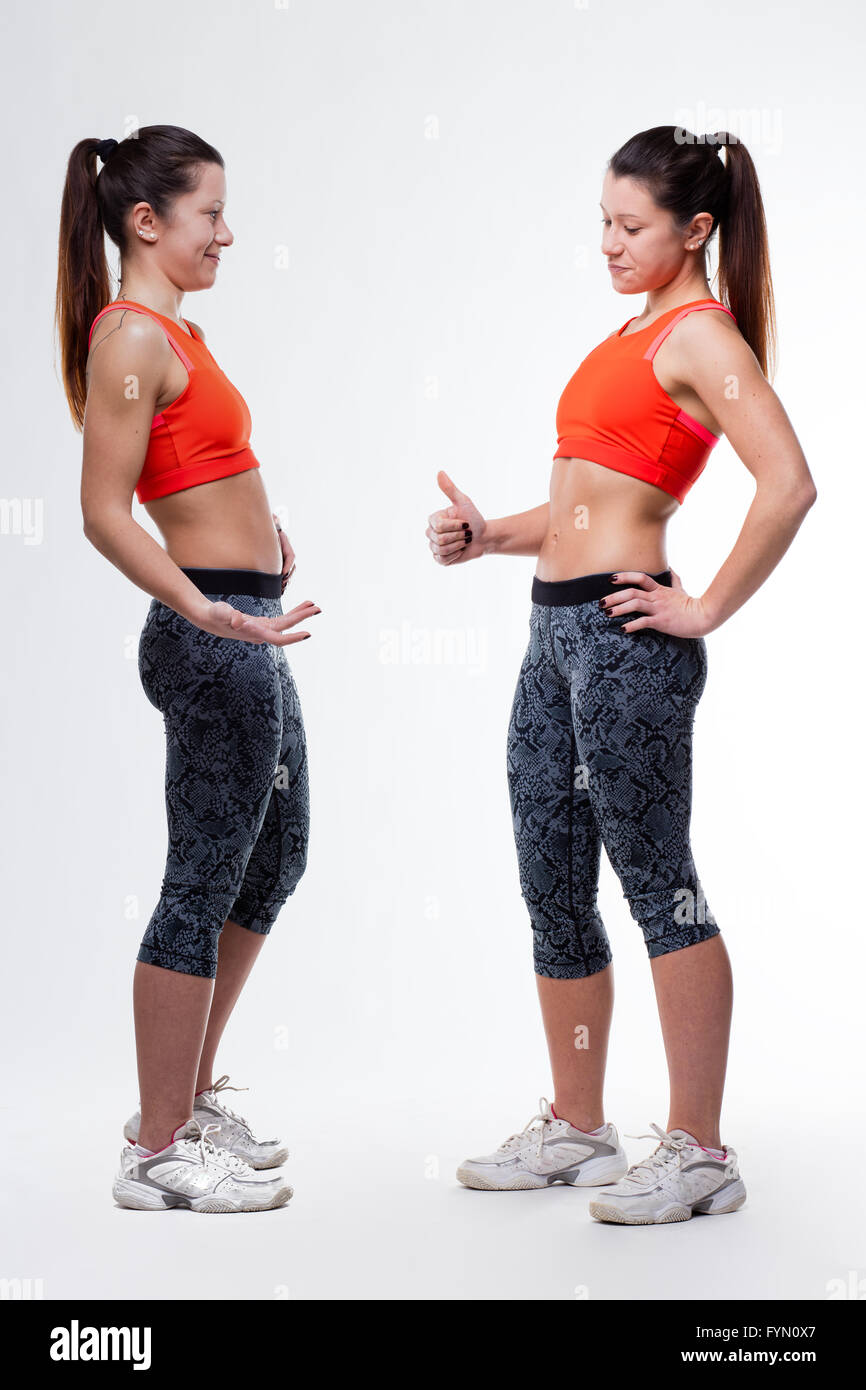 young woman looking at her perfect flat stomach and showing thumbs up ...