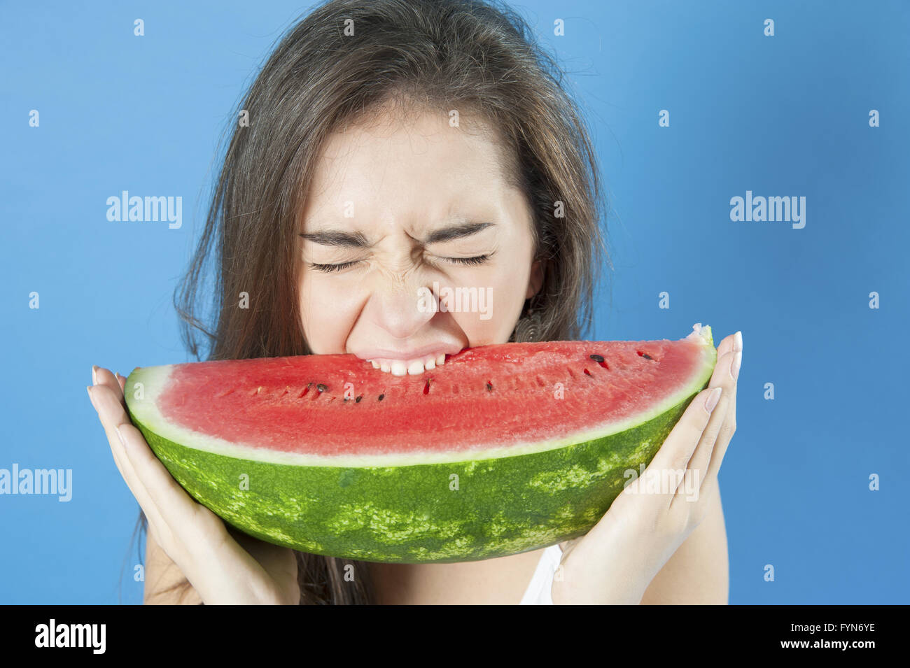 Girl biting a slice of watermelon Stock Photo - Alamy