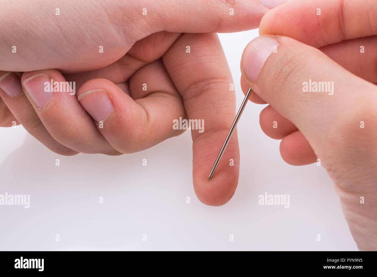 Hand holding a needle on a white background Stock Photo - Alamy