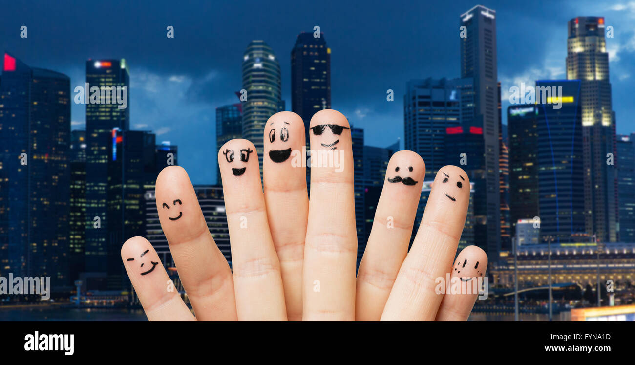 close up of fingers with smiley faces over city Stock Photo - Alamy