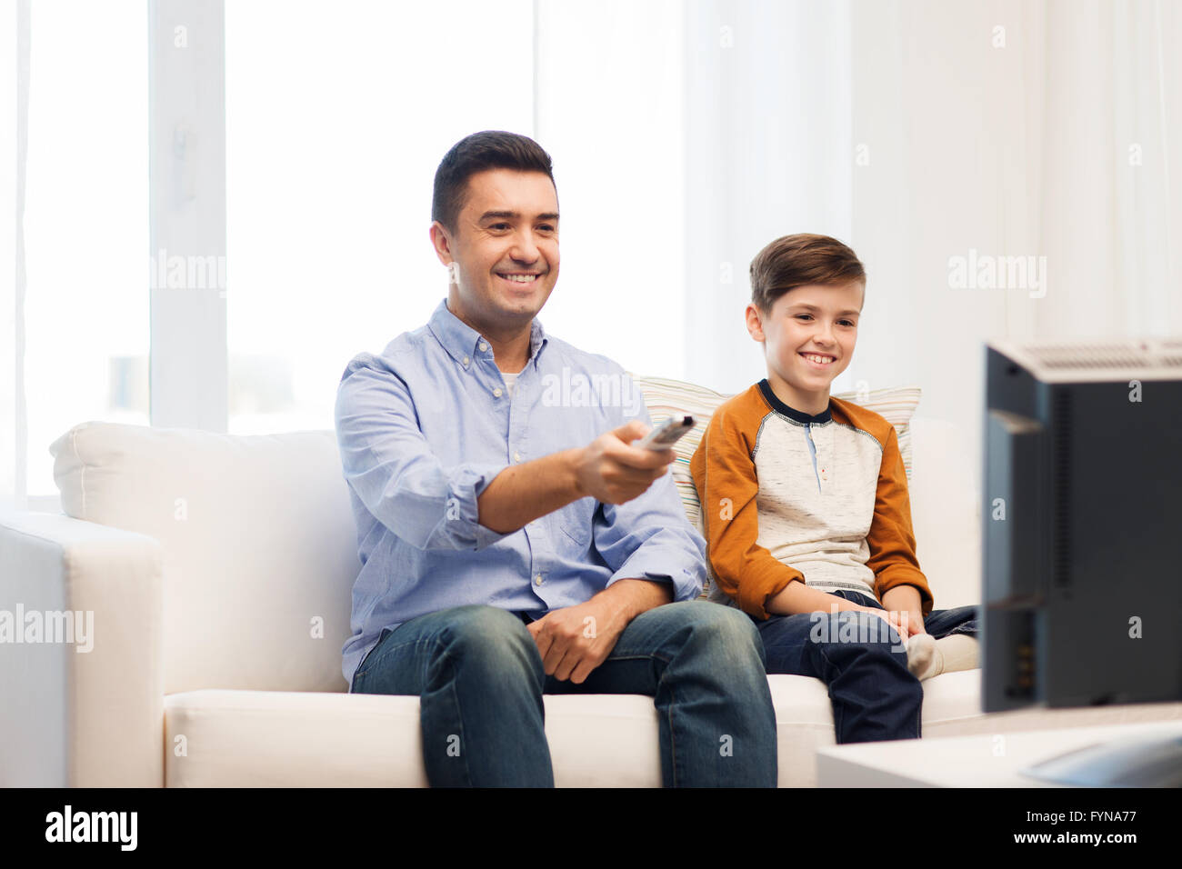 smiling father and son watching tv at home Stock Photo - Alamy