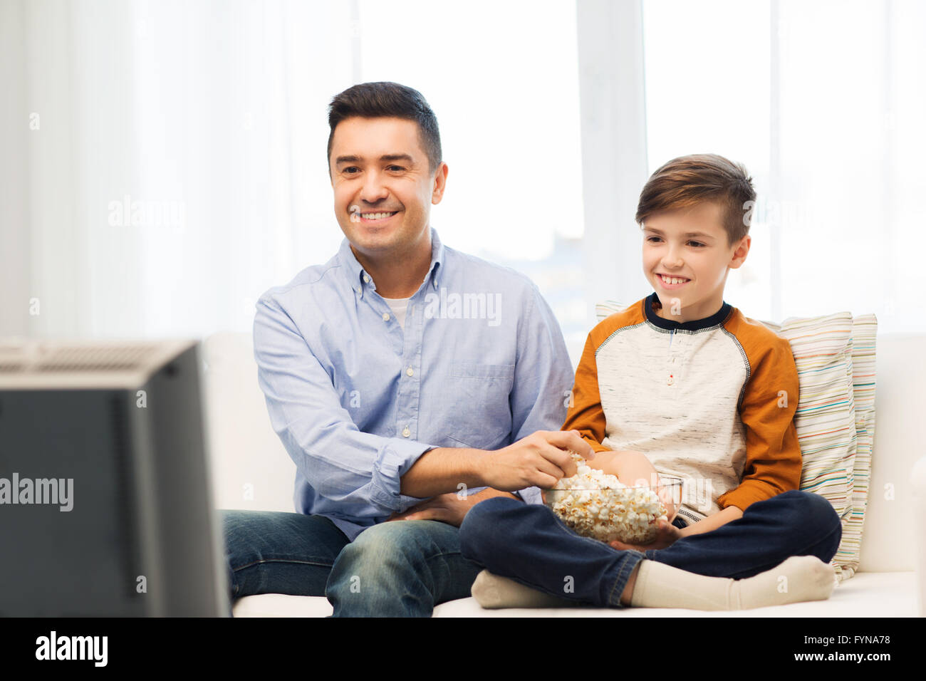 smiling father and son watching tv at home Stock Photo - Alamy