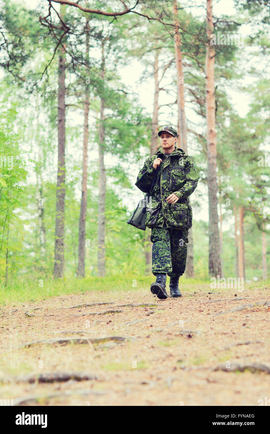 young soldier or hunter with gun in forest Stock Photo - Alamy