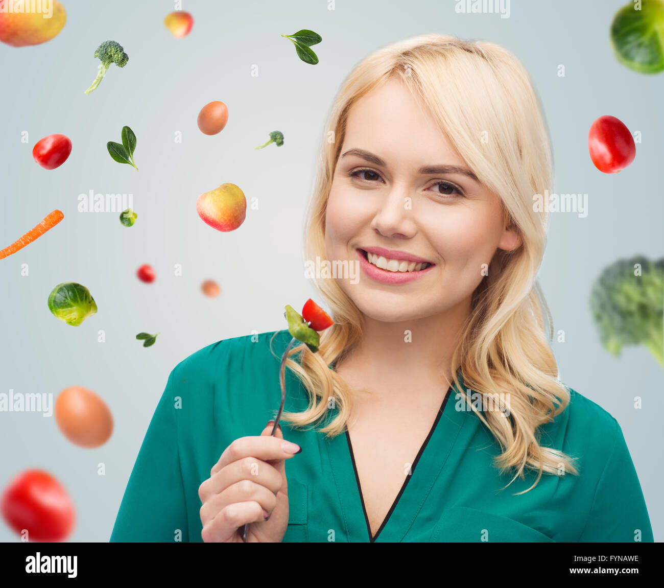 smiling young woman eating vegetable salad Stock Photo - Alamy