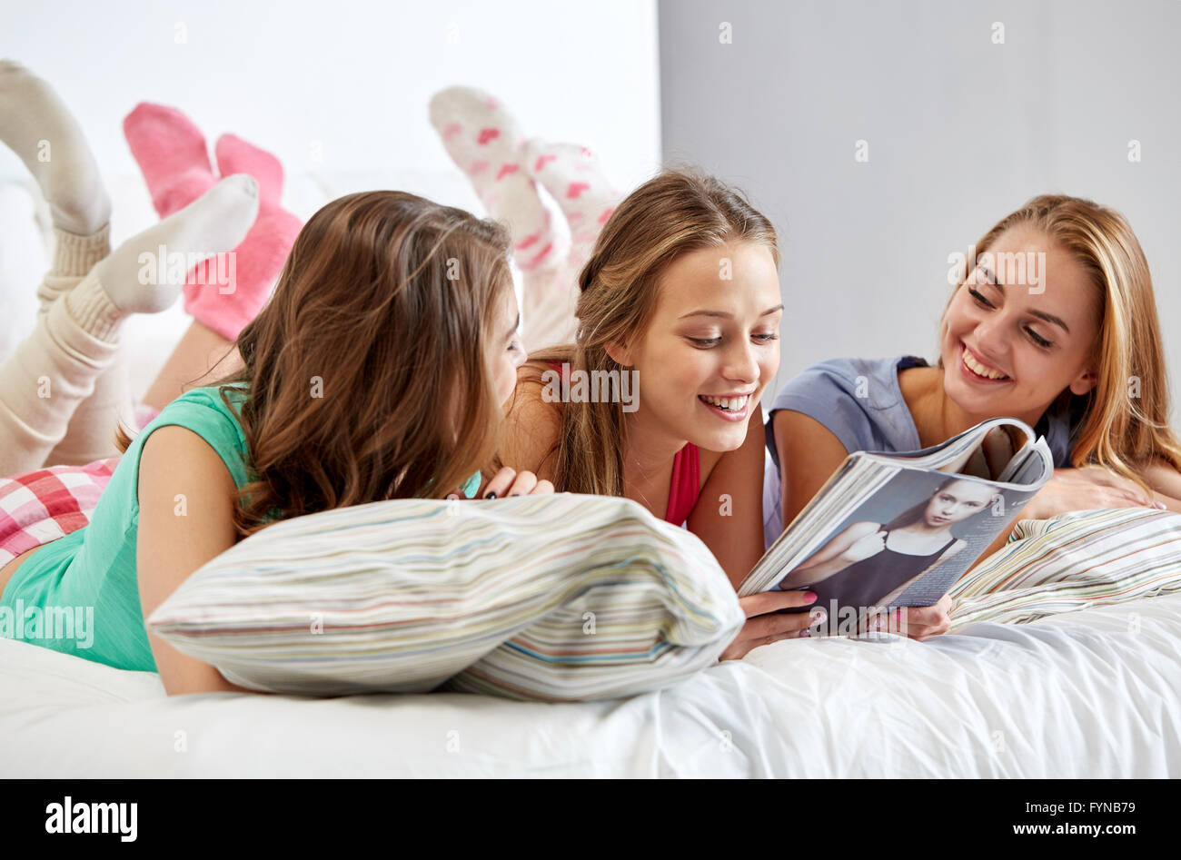 friends or teen girls reading magazine at home Stock Photo - Alamy