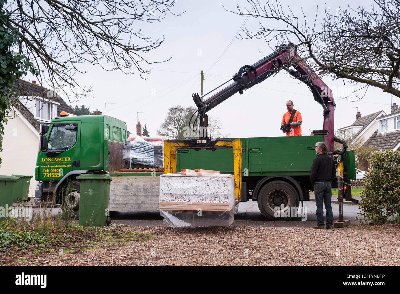 A builders supplier lorry unloading materials with crane in the Uk ...