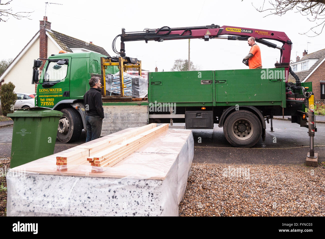 A builders supplier lorry unloading materials with crane in the Uk ...