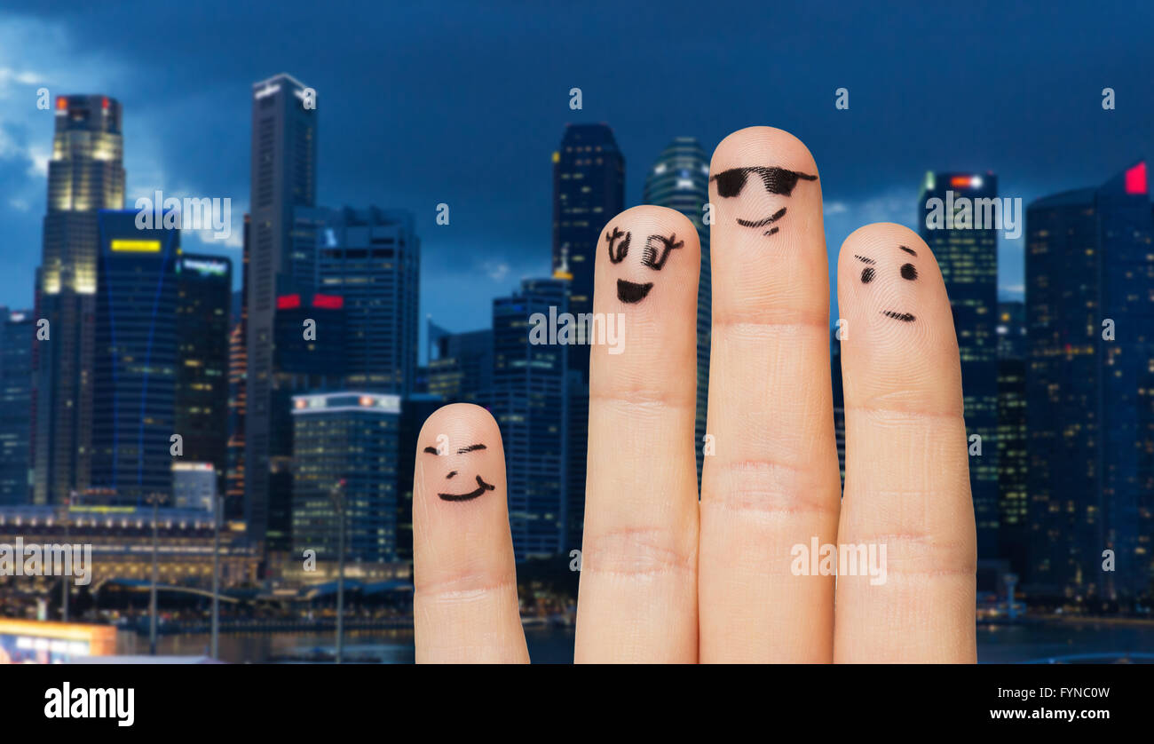 close up of fingers with smiley faces over city Stock Photo - Alamy