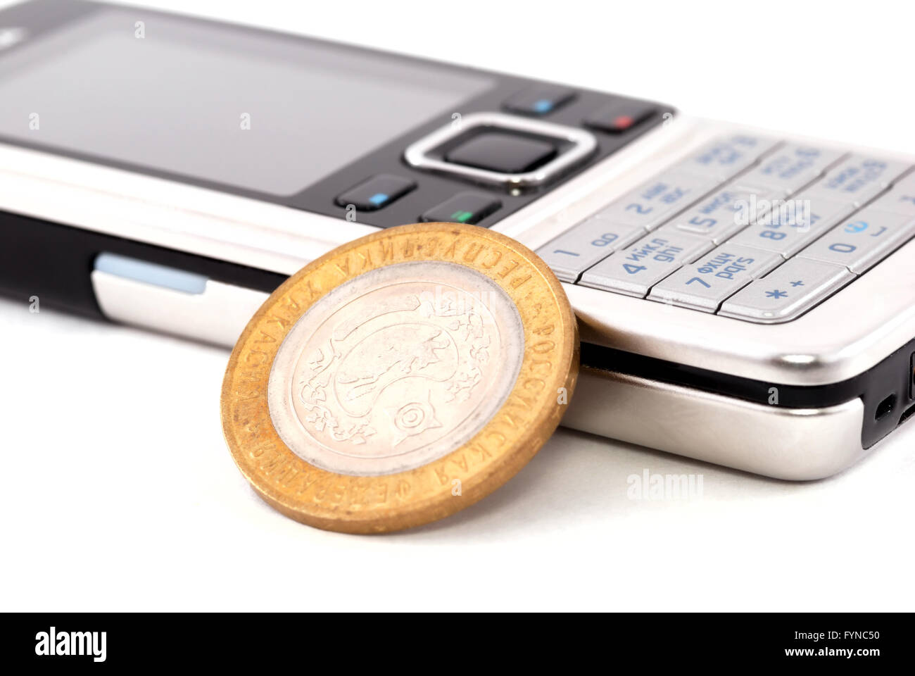 Mobile phone and coin Stock Photo - Alamy