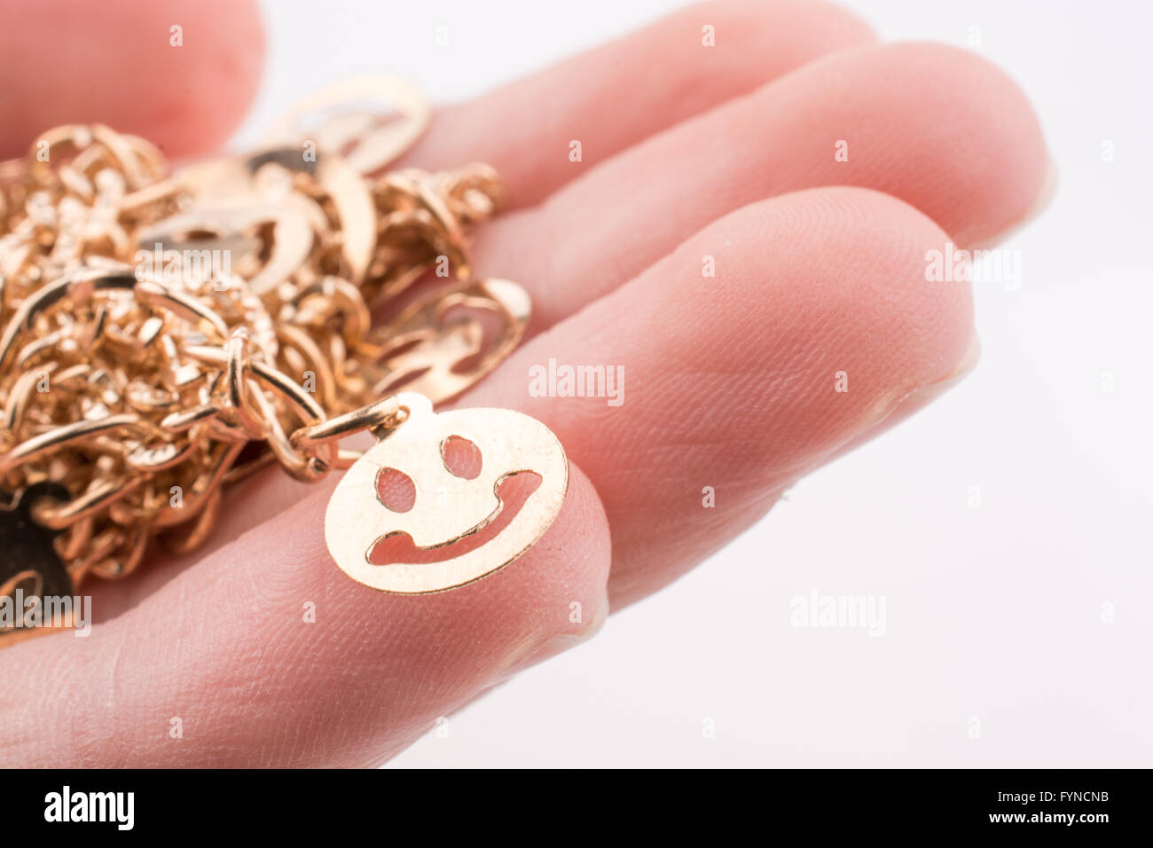Golden color smileys arrayed on a chain in hand Stock Photo - Alamy