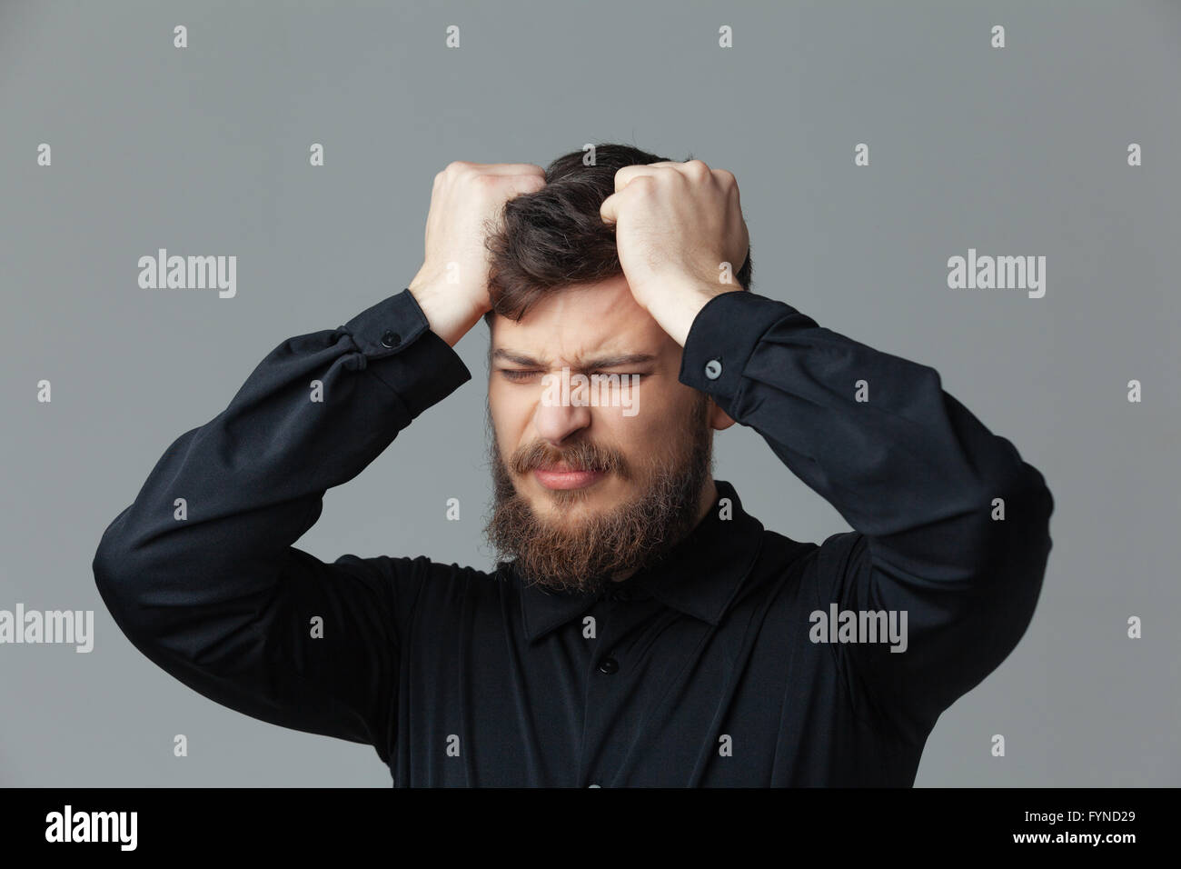 Stressed businessman standing over gray background Stock Photo - Alamy