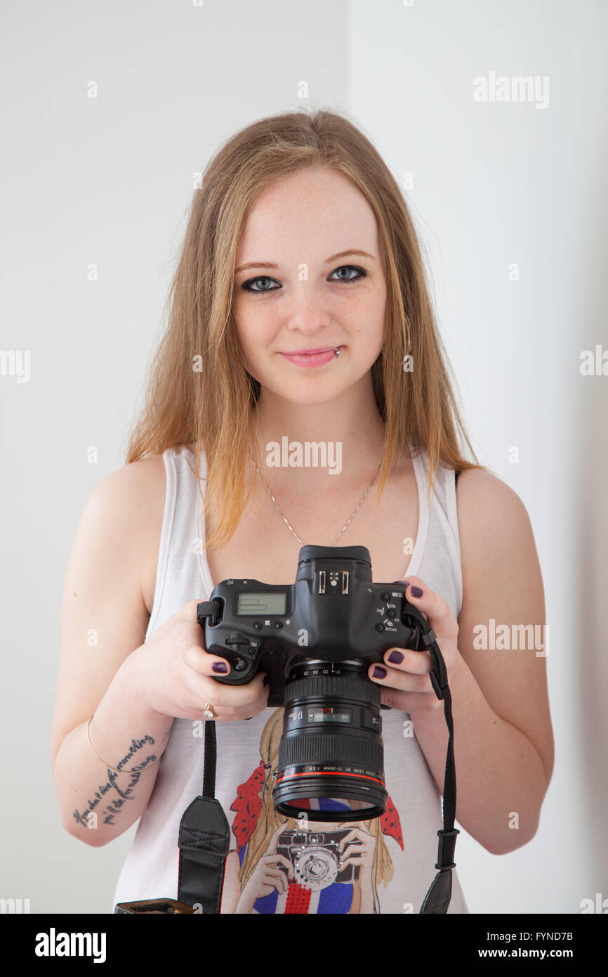 A pretty woman holding a digital camera in her hands Stock Photo - Alamy