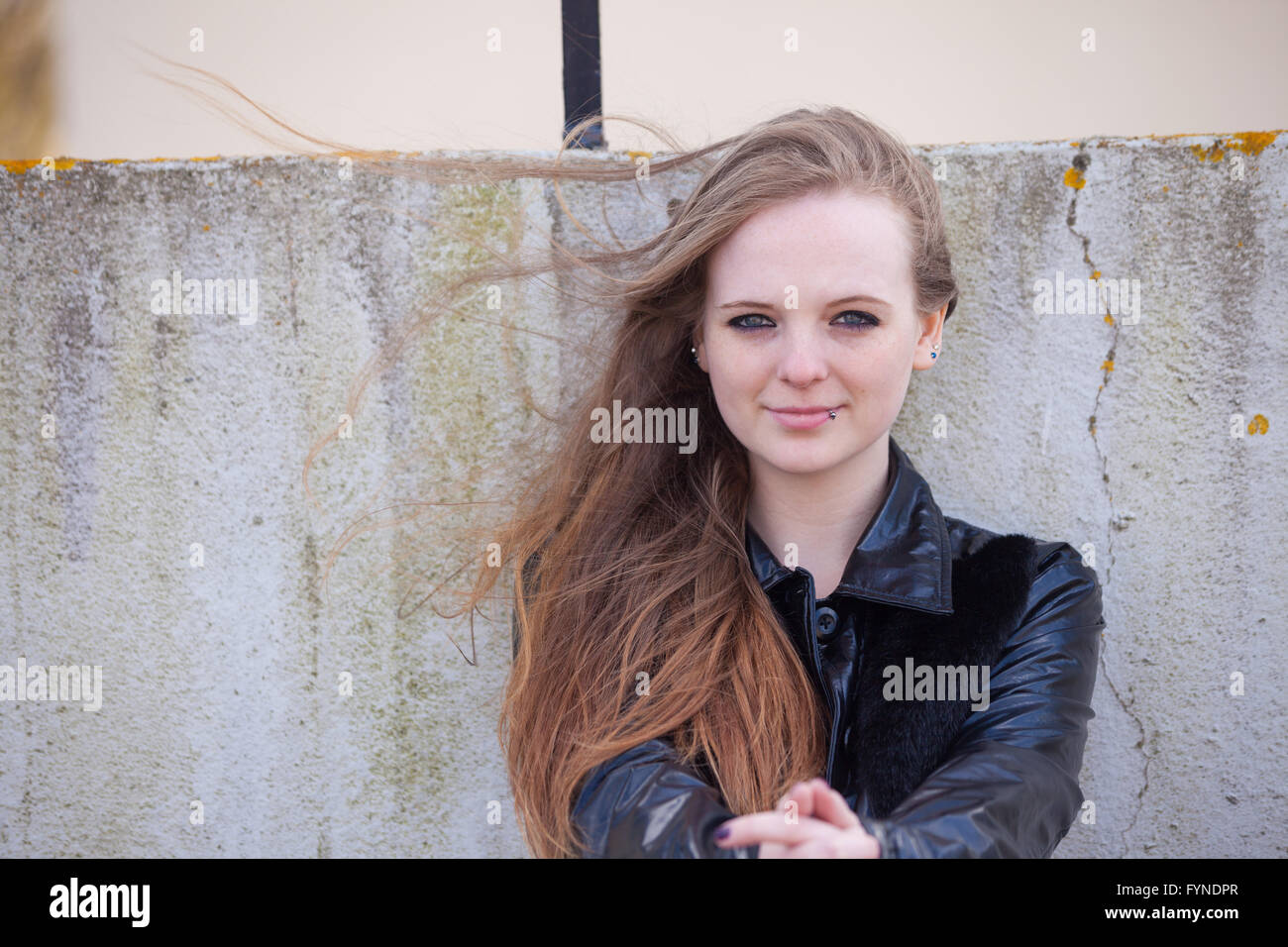 A woman sitting outside with long wind blown red hair Stock Photo - Alamy