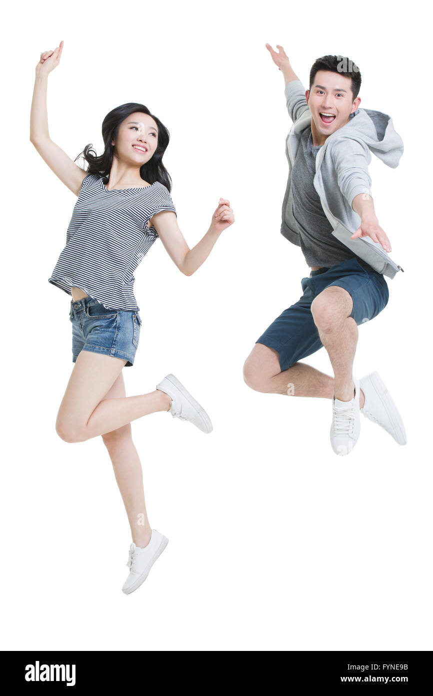 Happy young couple jumping Stock Photo - Alamy