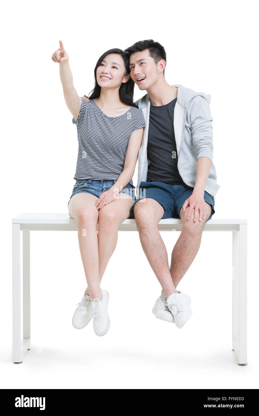 Happy young couple pointing Stock Photo - Alamy