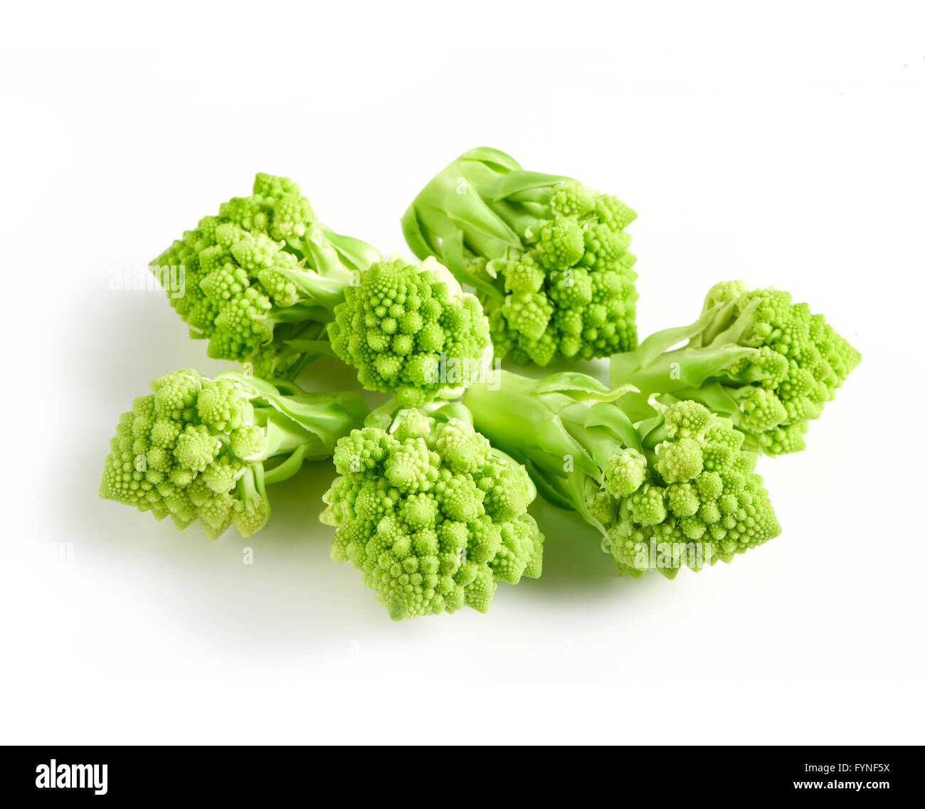 Cut florets of fresh green raw Romanesco broccoli displayed on a white ...