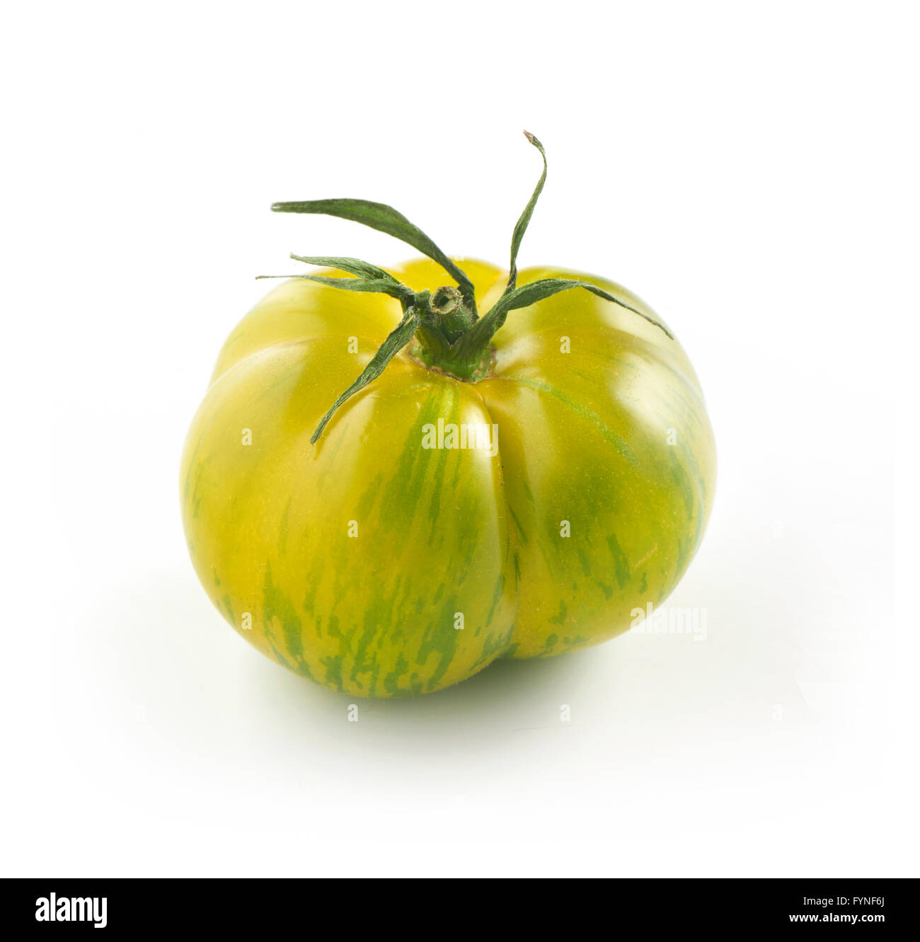 Single whole ripe green tiger tomato on a white background in a close ...