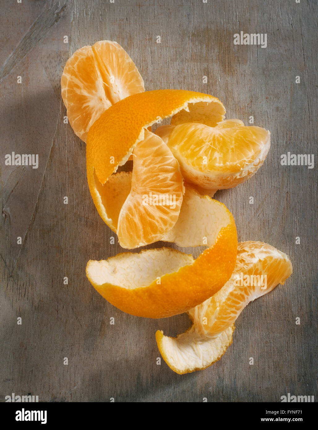Mandarin segments with spiral twirled peel displayed together on a ...