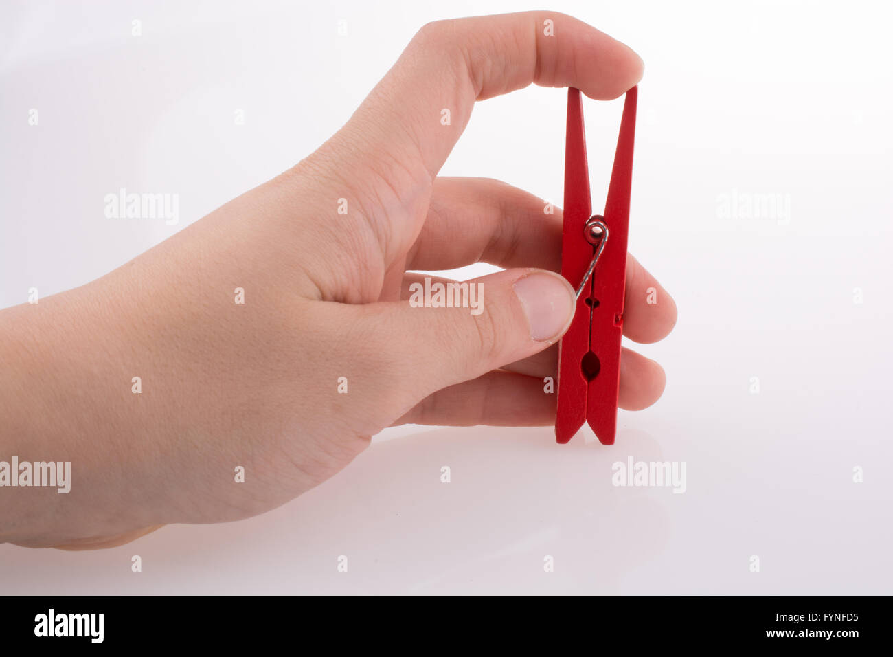 Hand holding a red clothespin on a white background Stock Photo - Alamy