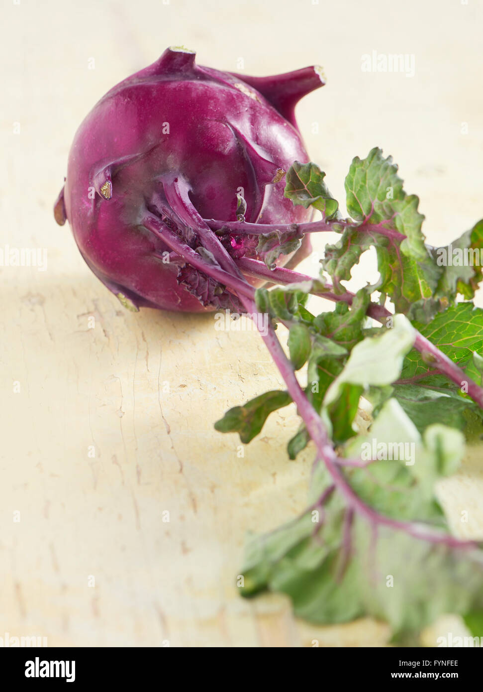 Whole fresh red kohlrabi with leaves displayed on a light wooden ...