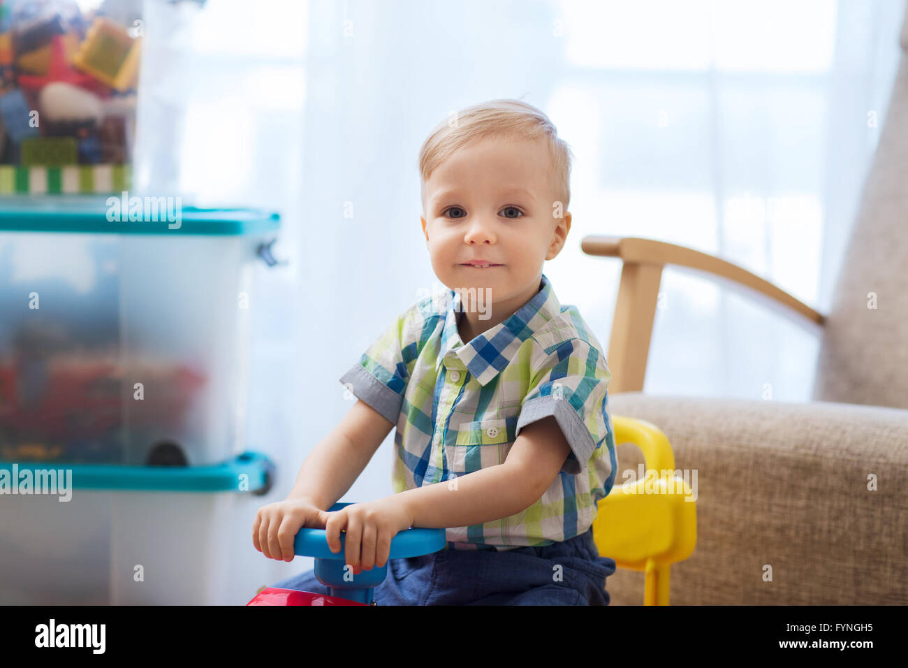 happy little baby boy driving ride-on car at home Stock Photo - Alamy