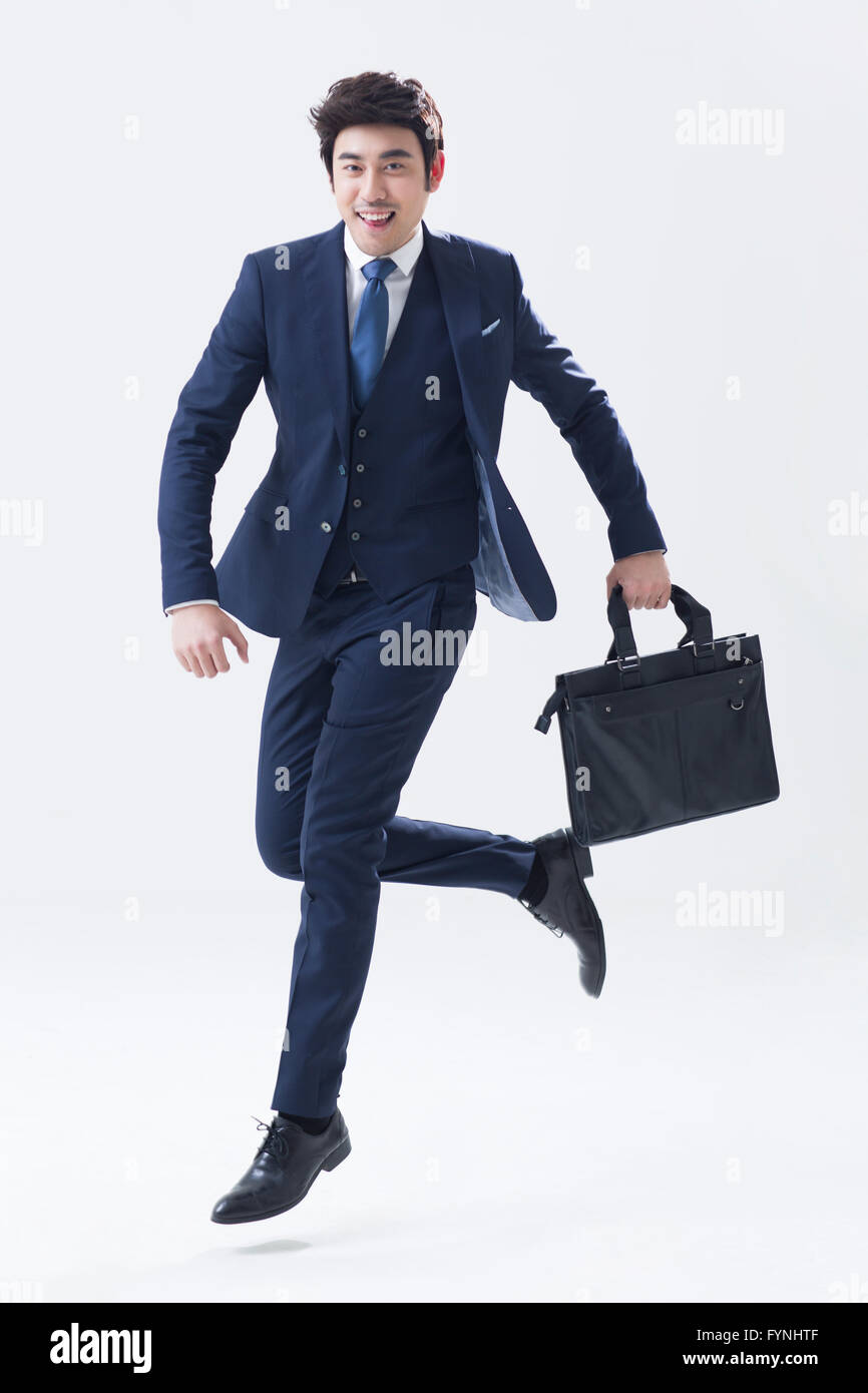 Young businessman running with briefcase Stock Photo - Alamy