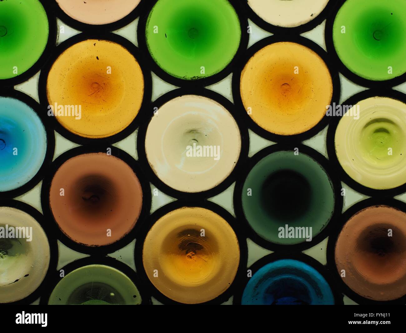 Multi-coloured glass bottle wall with translucent light Stock Photo - Alamy