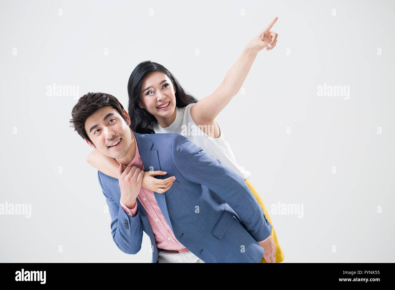 Happy young couple pointing Stock Photo - Alamy