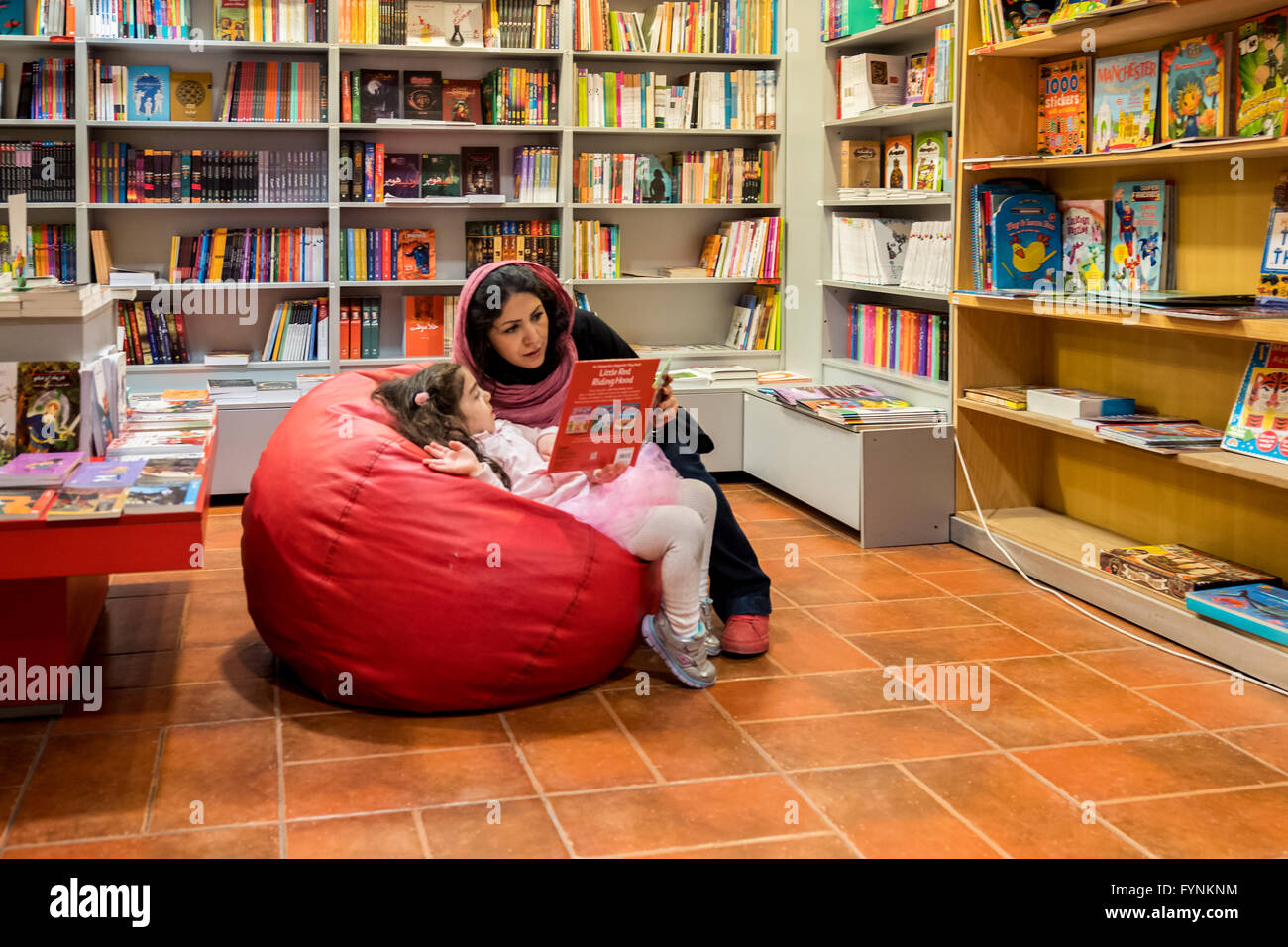 Mother Reading To Her Daughter In A Modern Book Store In Tehran Iran mother-reading-to-her-daughter-in-a-modern-book-store-in-tehran-iran