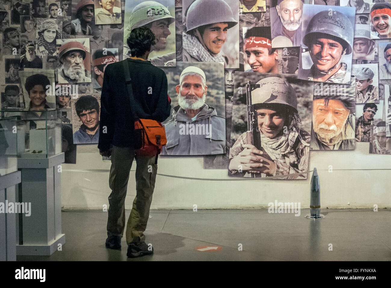 Visitor looks at photos of soldiers in the Iran-Iraq War in the Holy ...