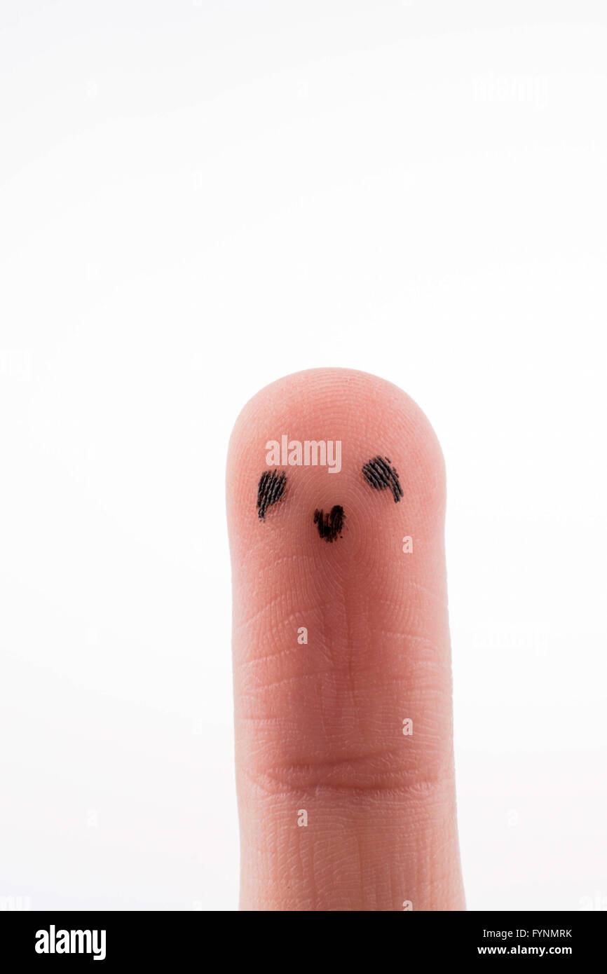 Black dots forming a face on the fingertip Stock Photo - Alamy