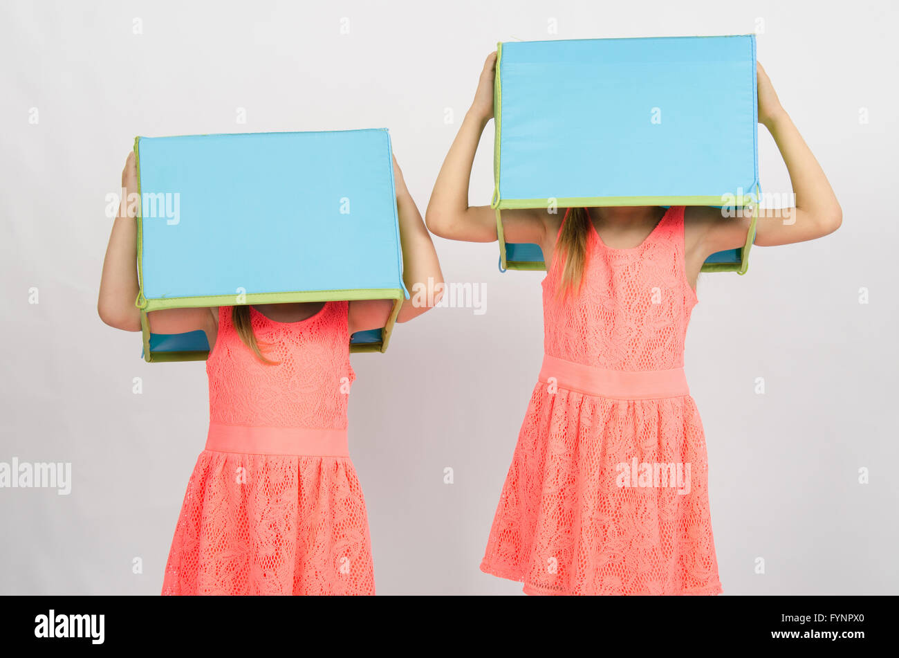 Two girls with boxes on their heads Stock Photo - Alamy