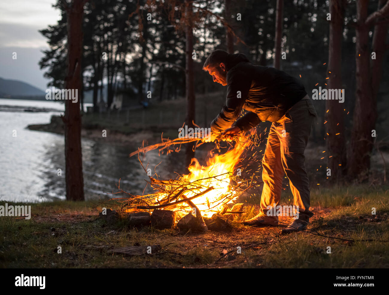 Man lights a fire in the fireplace in nature at night Stock Photo - Alamy