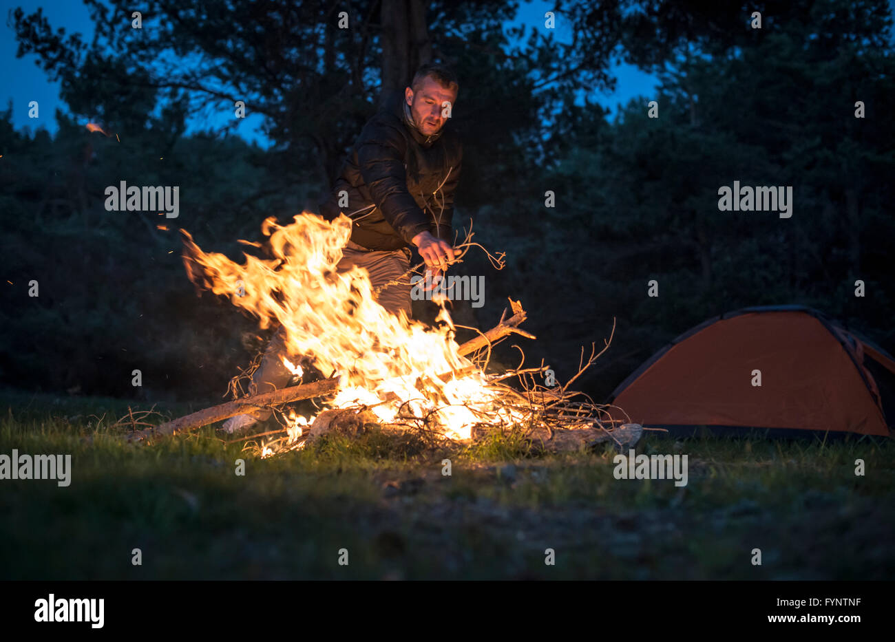 Man lights a fire in the fireplace in nature at night Stock Photo - Alamy