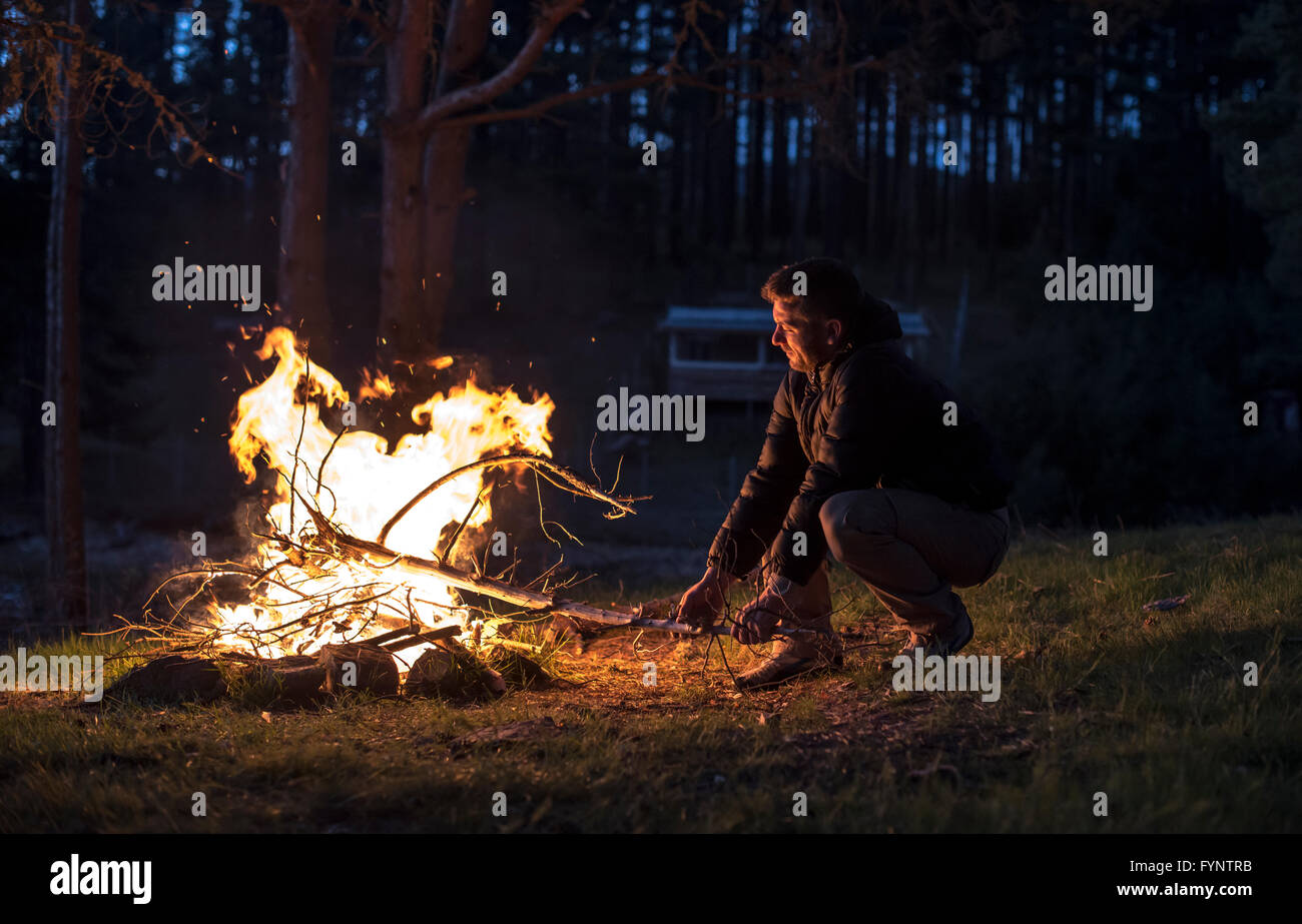 Man lights a fire in the fireplace in nature at night Stock Photo - Alamy