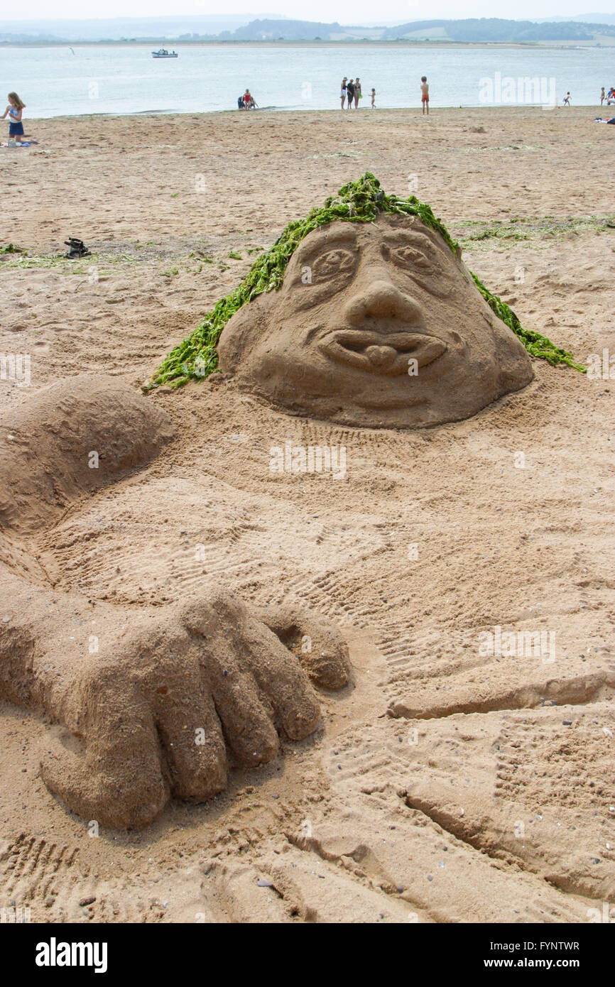 Sand sculpture of man with fist on the beach at Exmouth, Devon, England ...