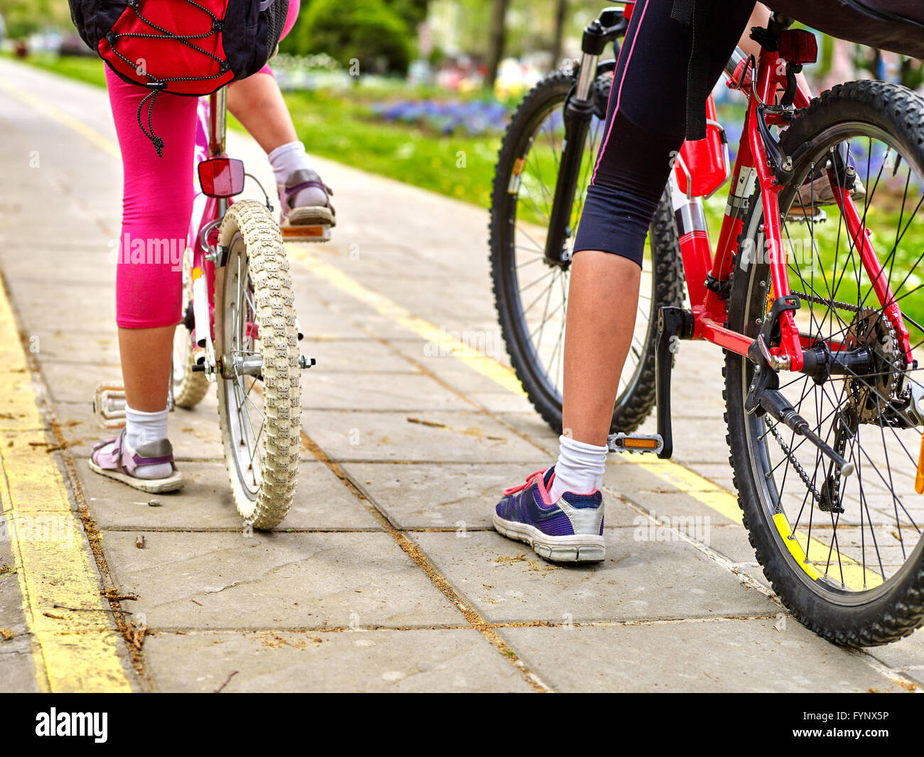 Bikes bicyclist girl. Children feet and bicycle wheel. Low section ...