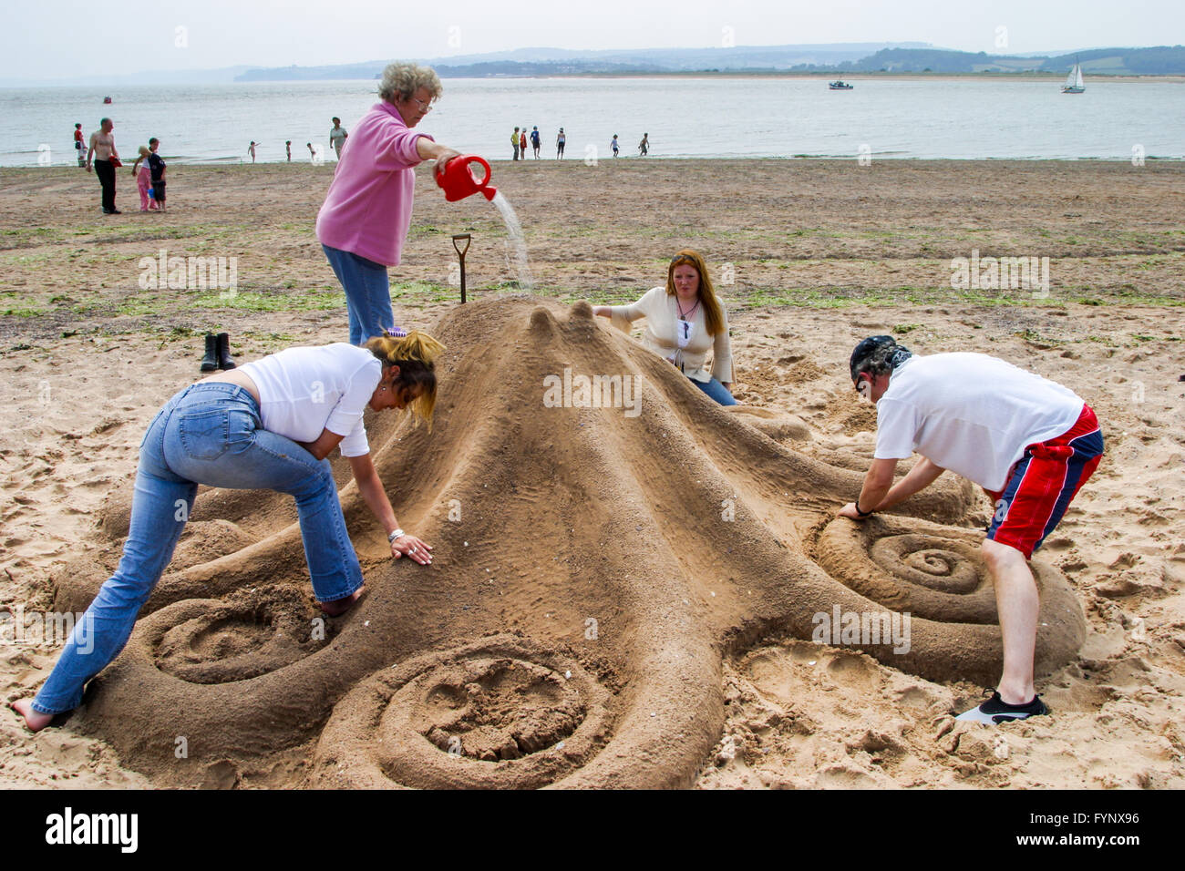Making a sand sculpture of an octopus on the beach at Exmouth, Devon ...