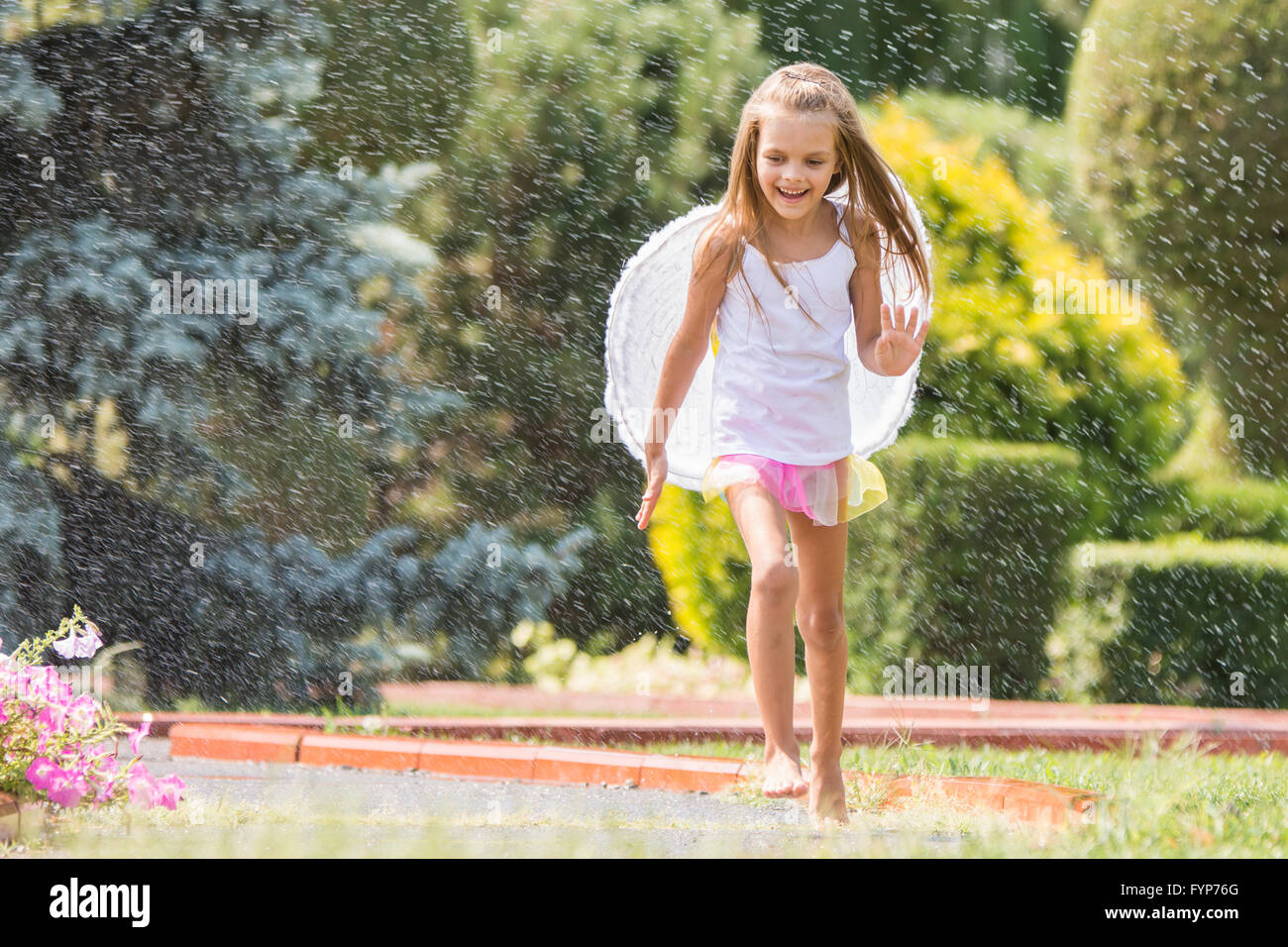 Girl with angel wings running around in the rain in the garden Stock ...