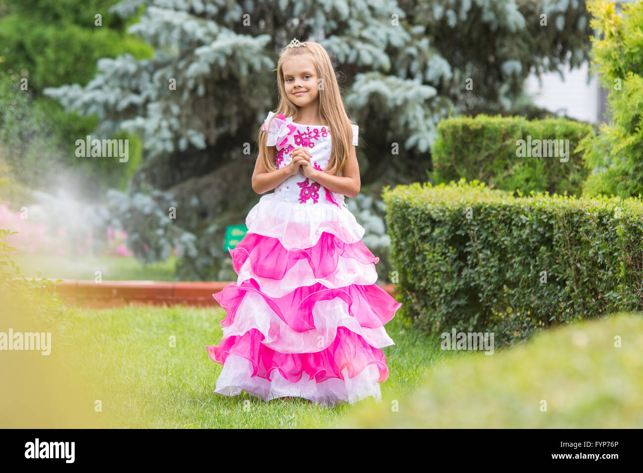 Girl princess stands on the lawn in the green garden Stock Photo - Alamy