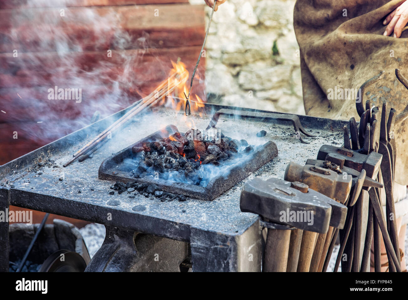 Artistic blacksmith works in the historic blacksmith workshop ...