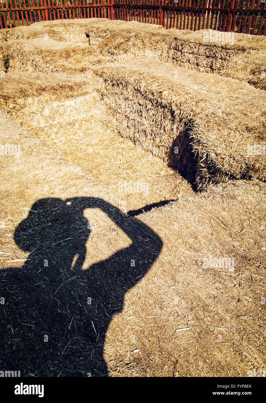 Photographer's shadow and haystacks. Straw bales. Silhouette of man ...
